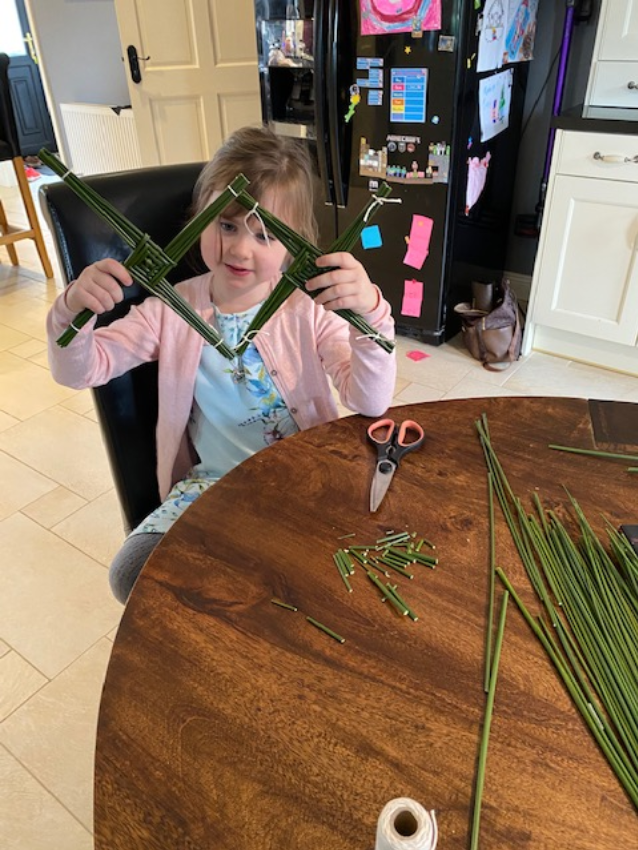 Sorcha making Saint Brigid's crosses